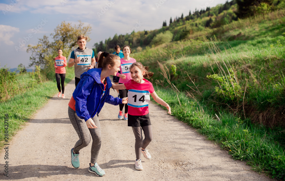 Large group of multi generation people running a race competition in ...