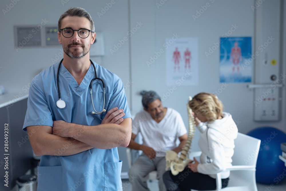 Male surgeon with arm crossed looking at camera in hospital Stock Photo ...
