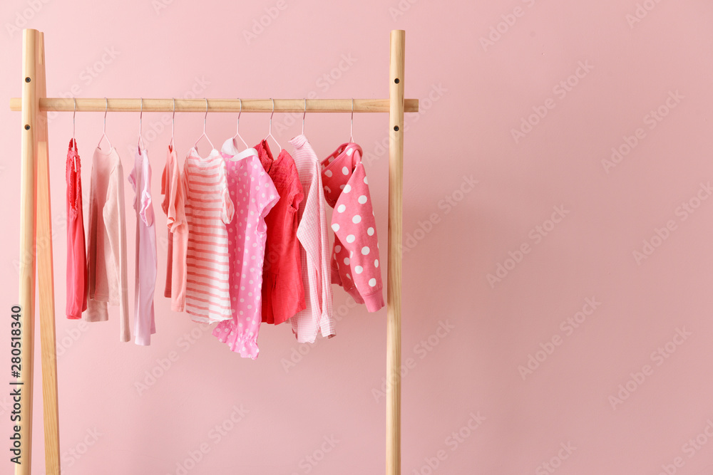 Rack with hanging clothes on color background Stock Photo | Adobe Stock