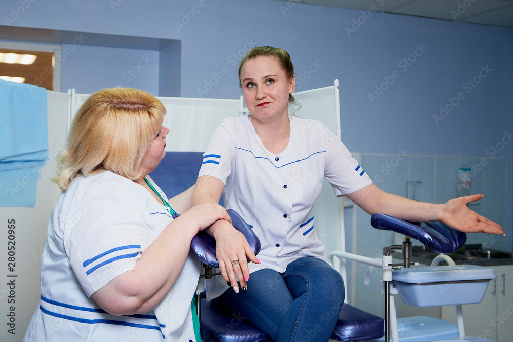 Experienced doctor fat woman teaching aspiring young doctor how to do ...