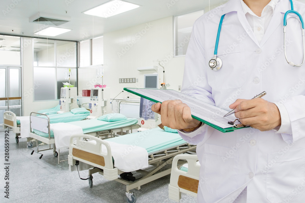 Doctor writing chart with patient bed in hospital room background ...