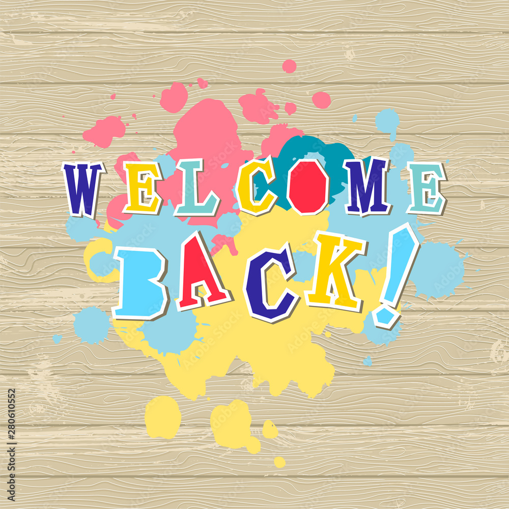 Welcome back text isolated on wooden background with paint spots. Place ...