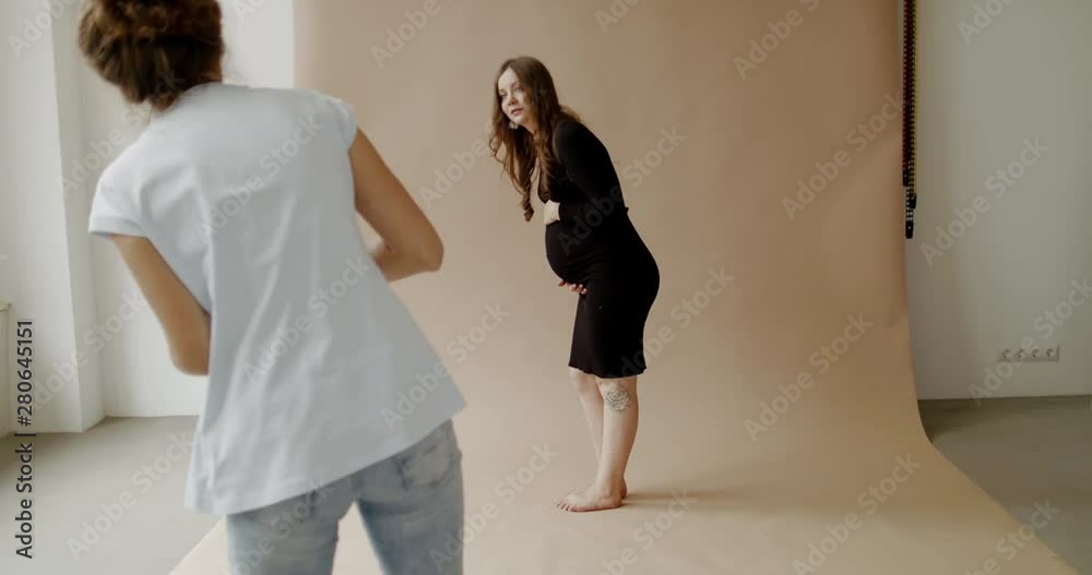 Backstage of the photo shoot: Beautiful caucasian pregnant model posing ...