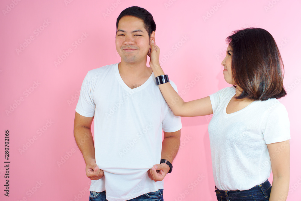 Photos Couple Woman pulling ears when I'm doing wrong. Background pink ...
