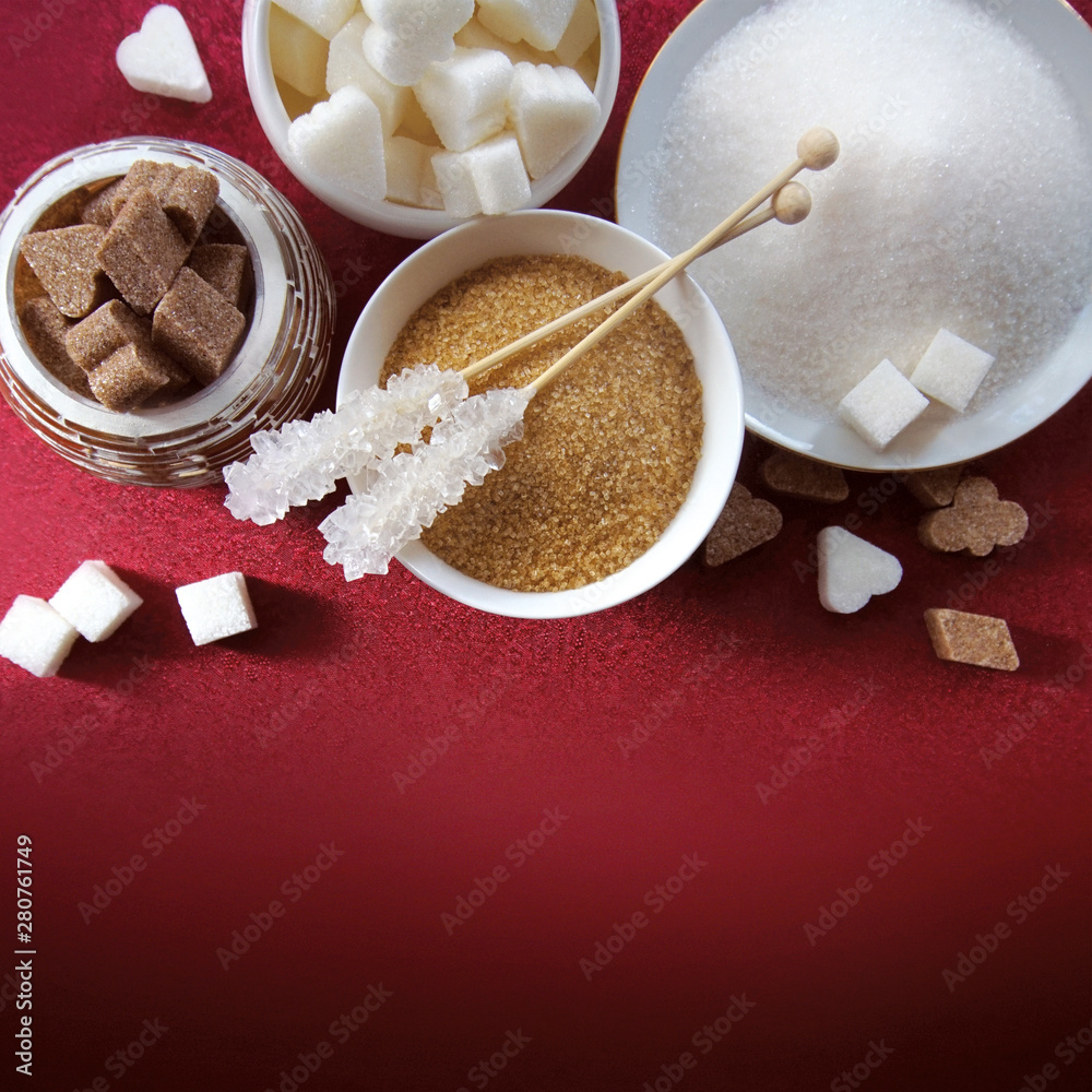 Various types and shapes of sugar on red background with empty space ...