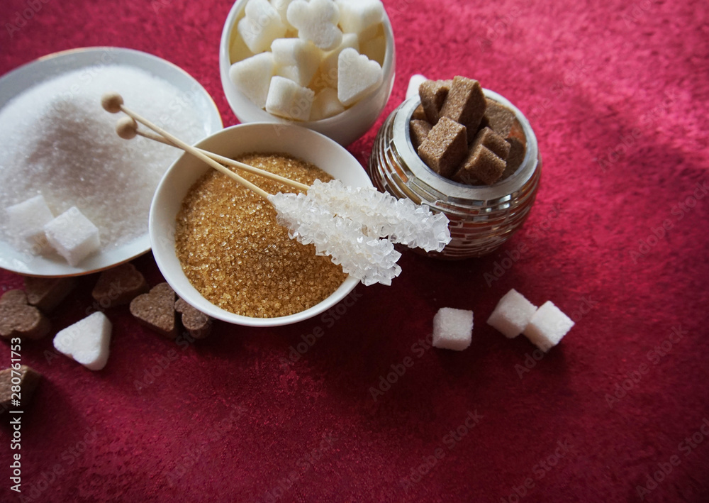 Various types and shapes of sugar on red background with empty space ...