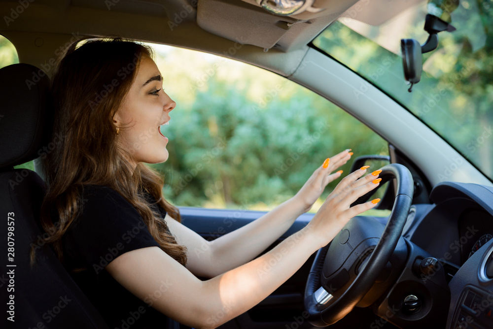 Young girl driver sitting in the car with open mouth and crying before ...