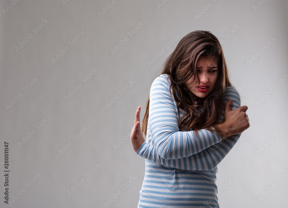 Scared fearful young woman hugging herself Stock Photo | Adobe Stock