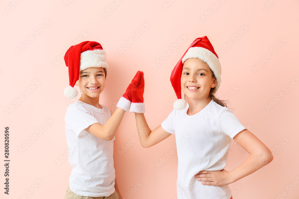 Happy little children in Santa hats giving high-five to each other ...