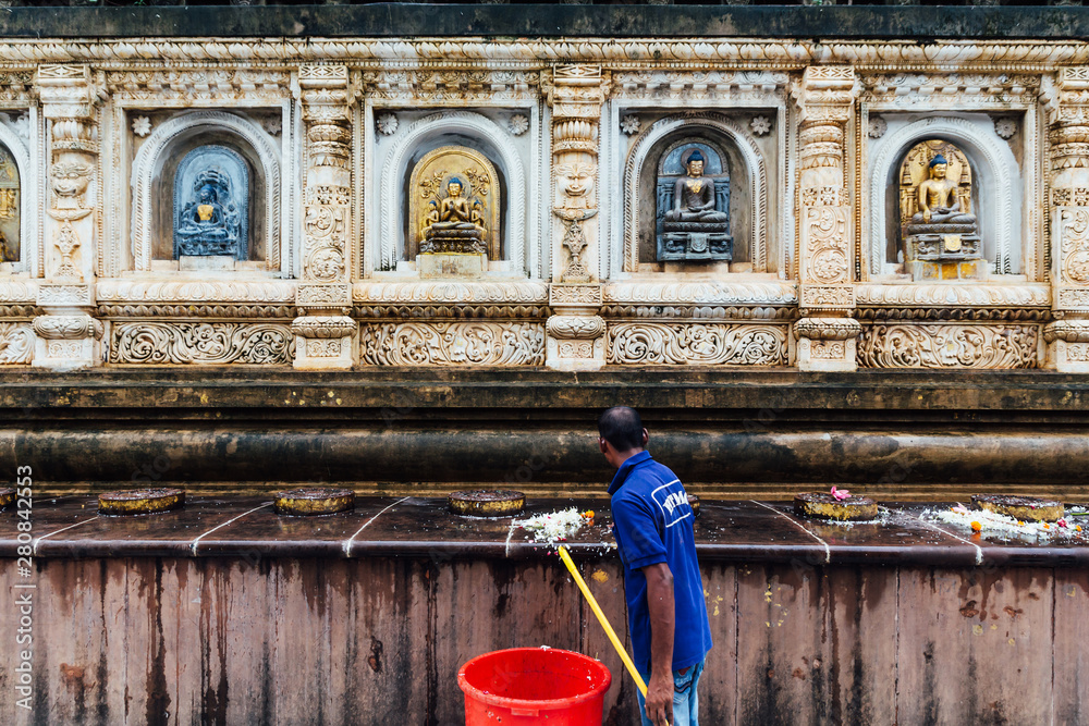 Janitor man cleaning wall of the temple that decorated with many forms ...