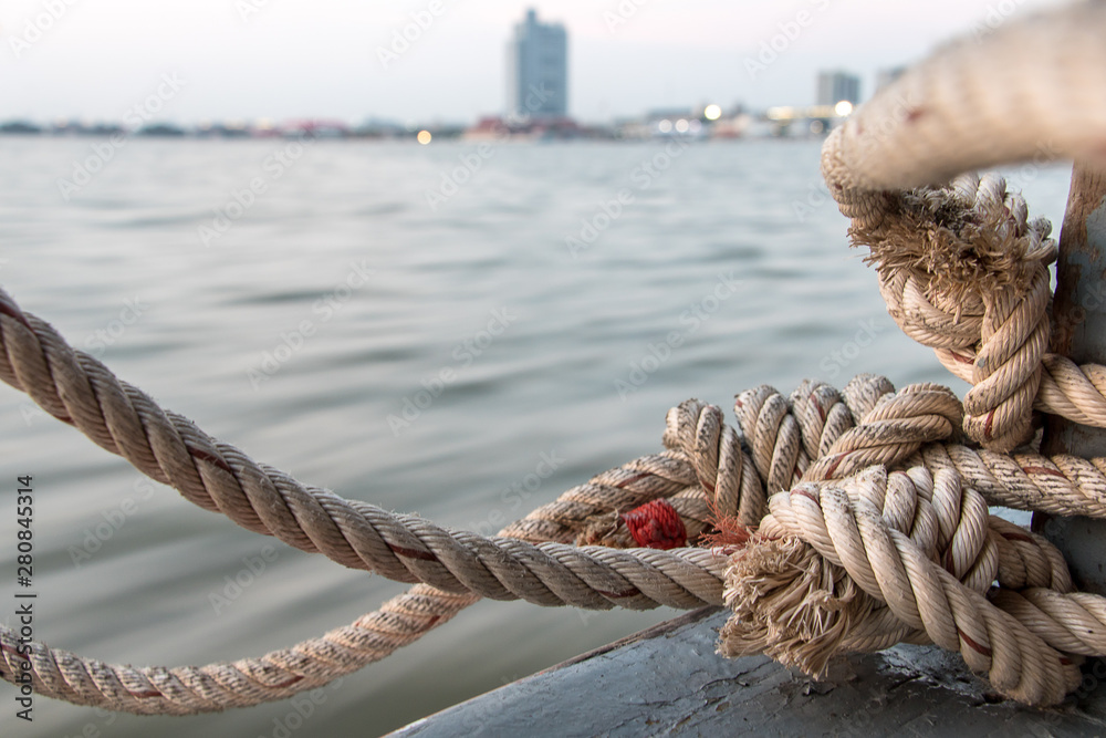 Boat rope tied to a wooden post on a floating boat railing, close up ...