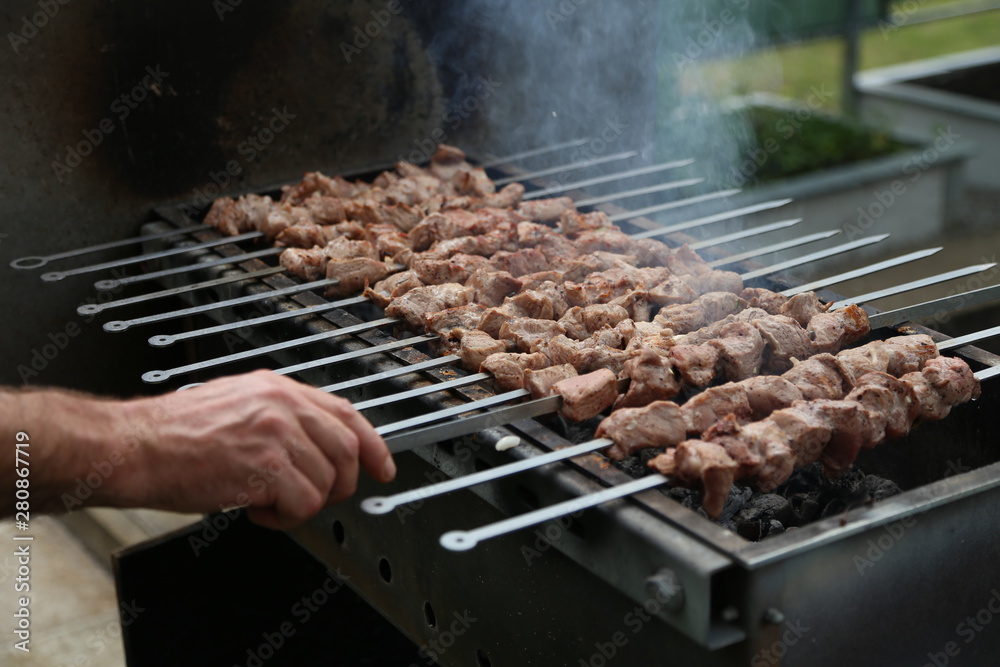 Foto de Roasted meat cooked at barbecue with smoke. Traditional eastern ...