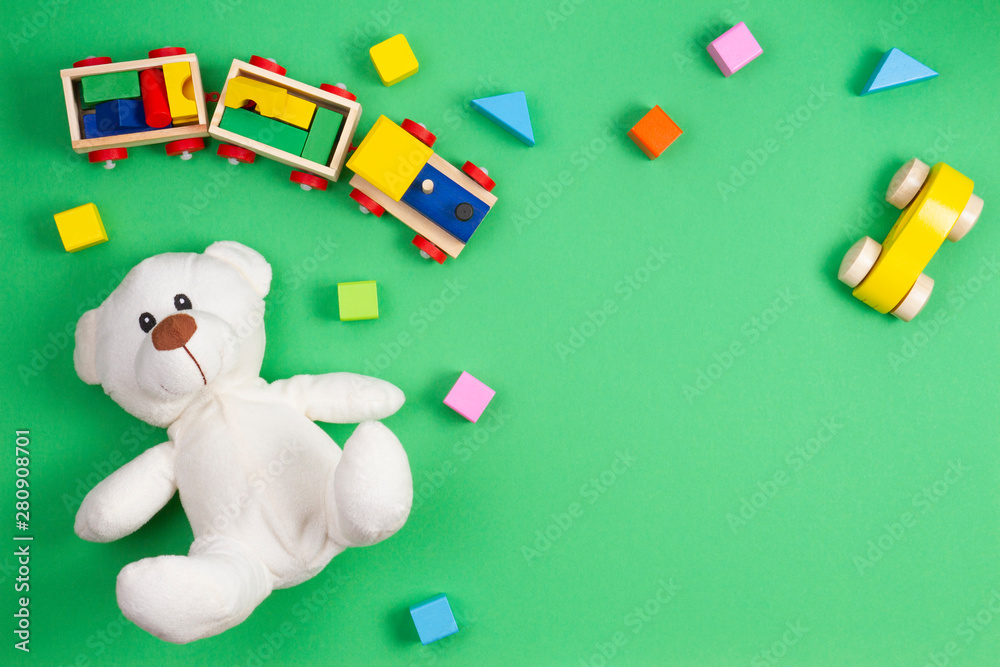 Baby kids toys background. White teddy bear, wooden toy train and car ...