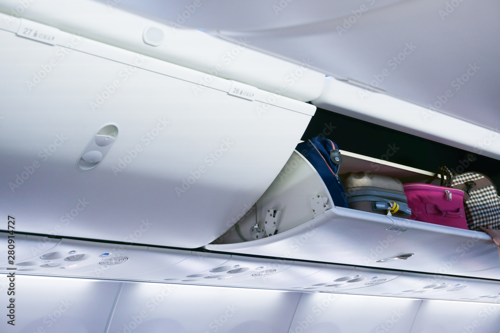 Airplane cabine with the luggage compartments,luggage ready for ...