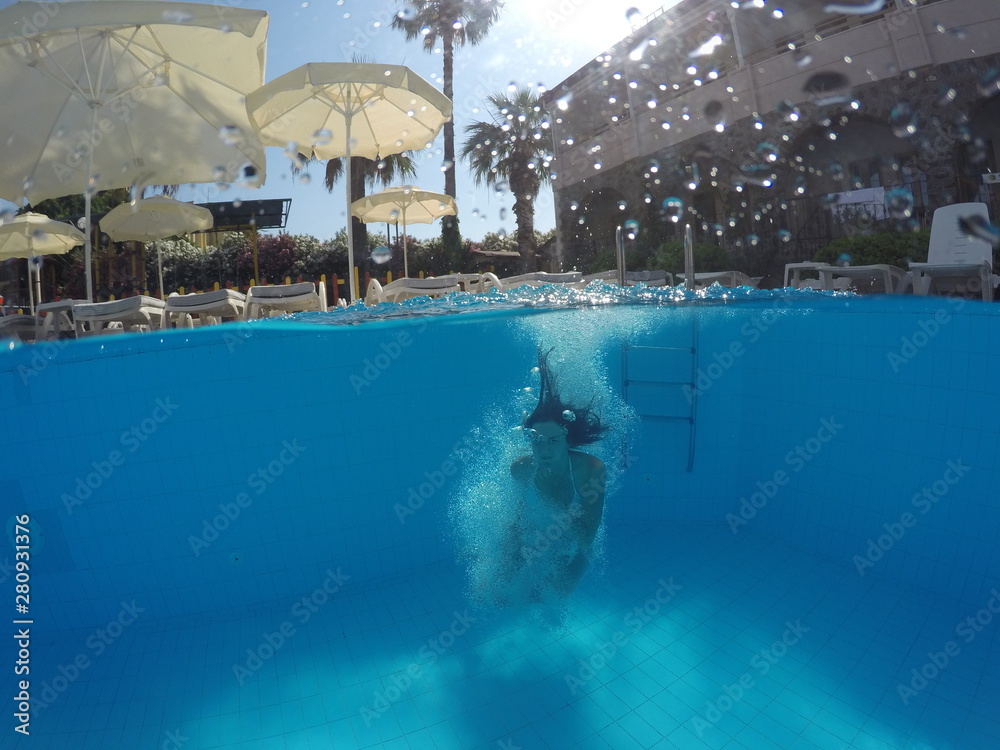 underwater shooting woman in a black swimsuit swimming in the pool ...