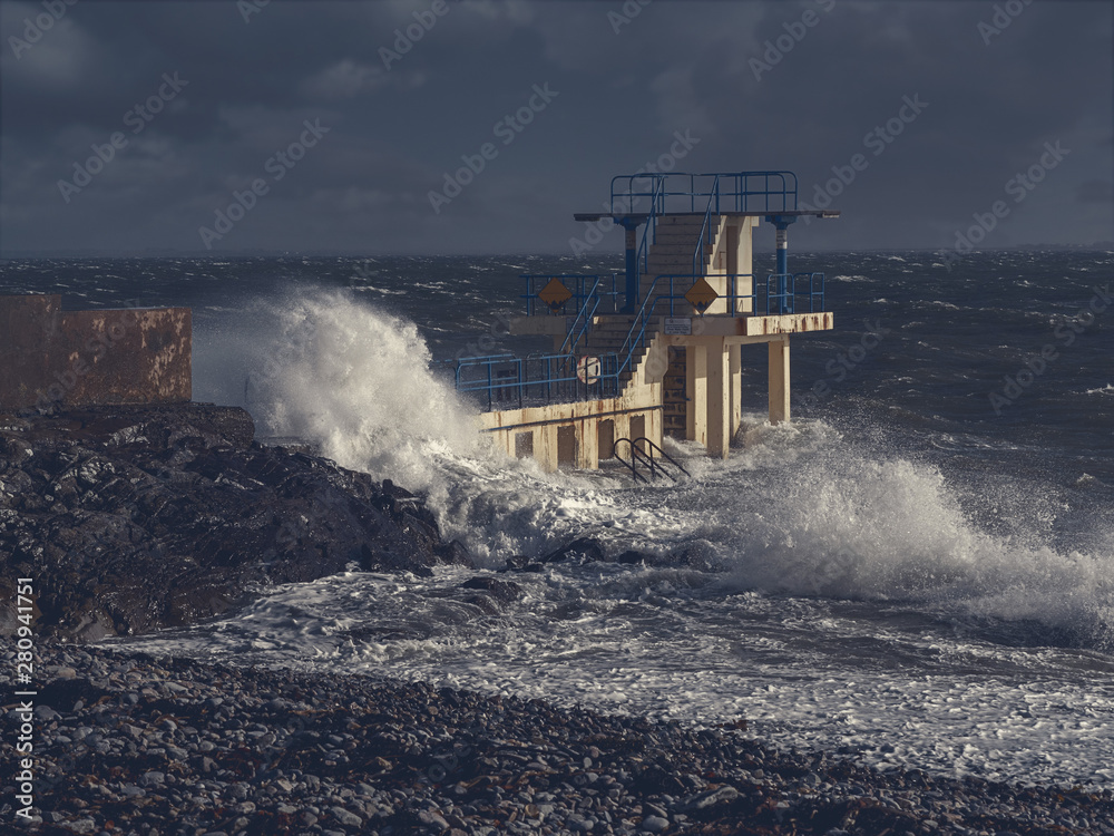 Black Rock diving rock at storm and high tide covered by a giant splash ...