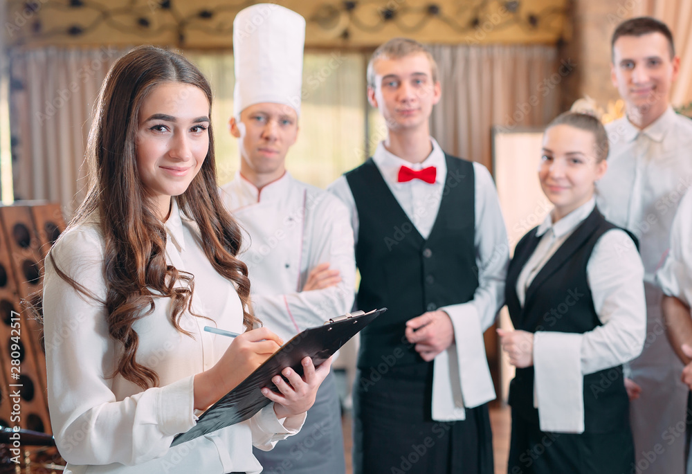 restaurant manager and his staff in kitchen. interacting to head chef ...