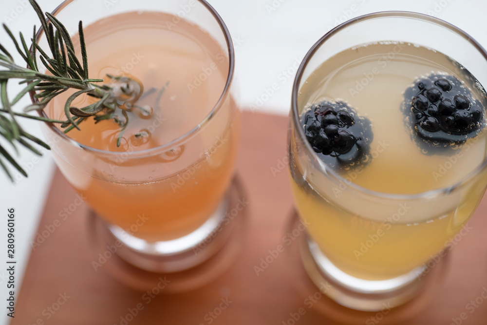 Mimosa flight with blackberries, champagne and rosemary on a wood and ...