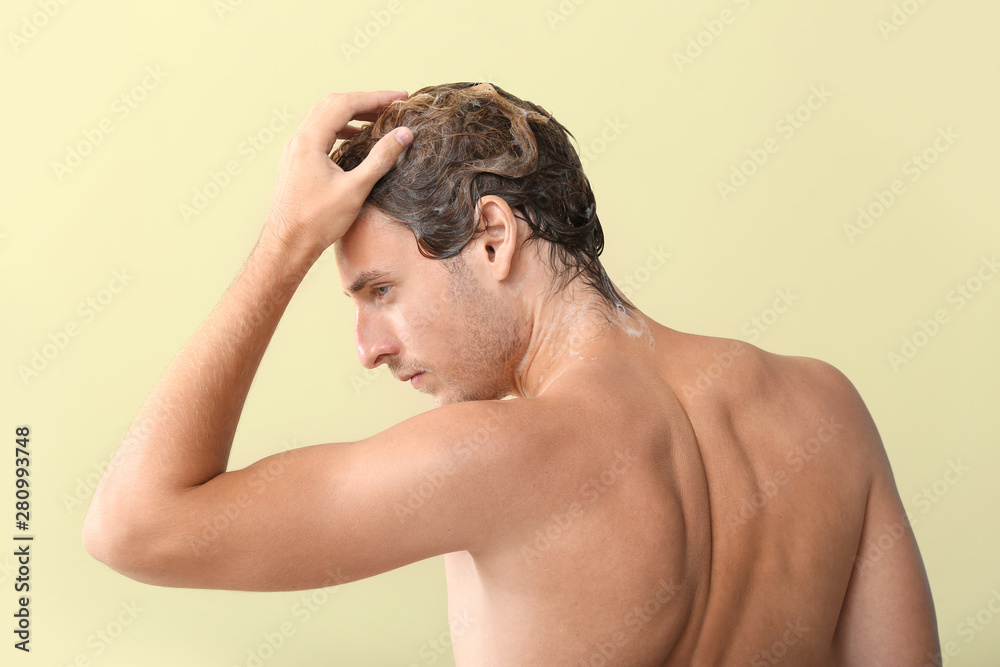 Handsome young man washing hair against color background Stock Photo ...