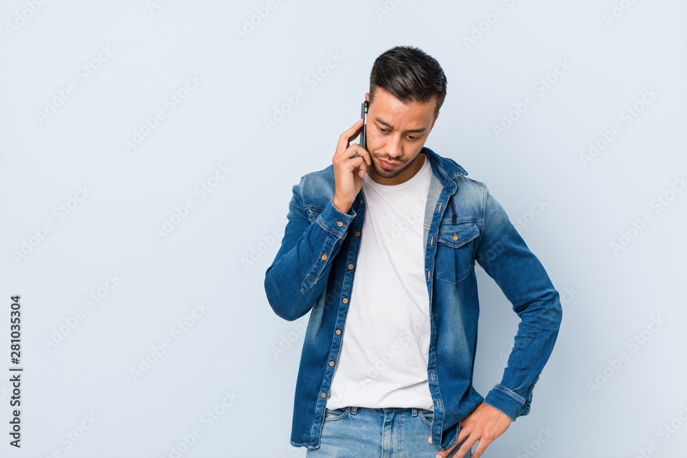 Young filipino man talking on phone Stock Photo | Adobe Stock