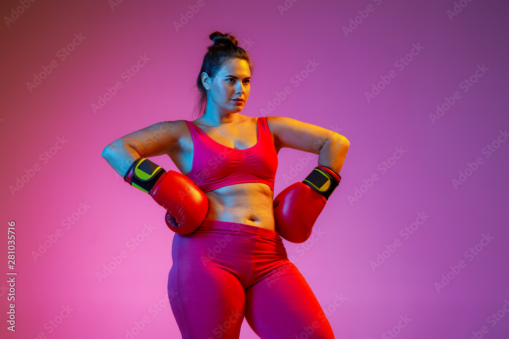 Young caucasian plus size female model's doing exercises on gradient ...