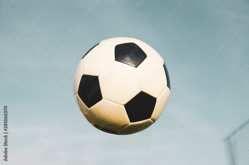 Soccer ball in mid air, blue sky background Stock Photo | Adobe Stock