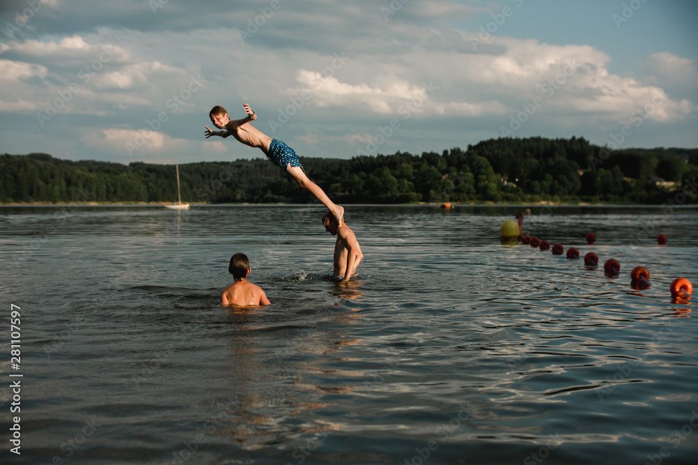 teen boy jumping off the shoulders of friend in lake Stock Photo ...