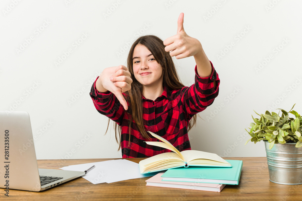 Young teenager going back to her routine doing homeworks showing thumbs ...