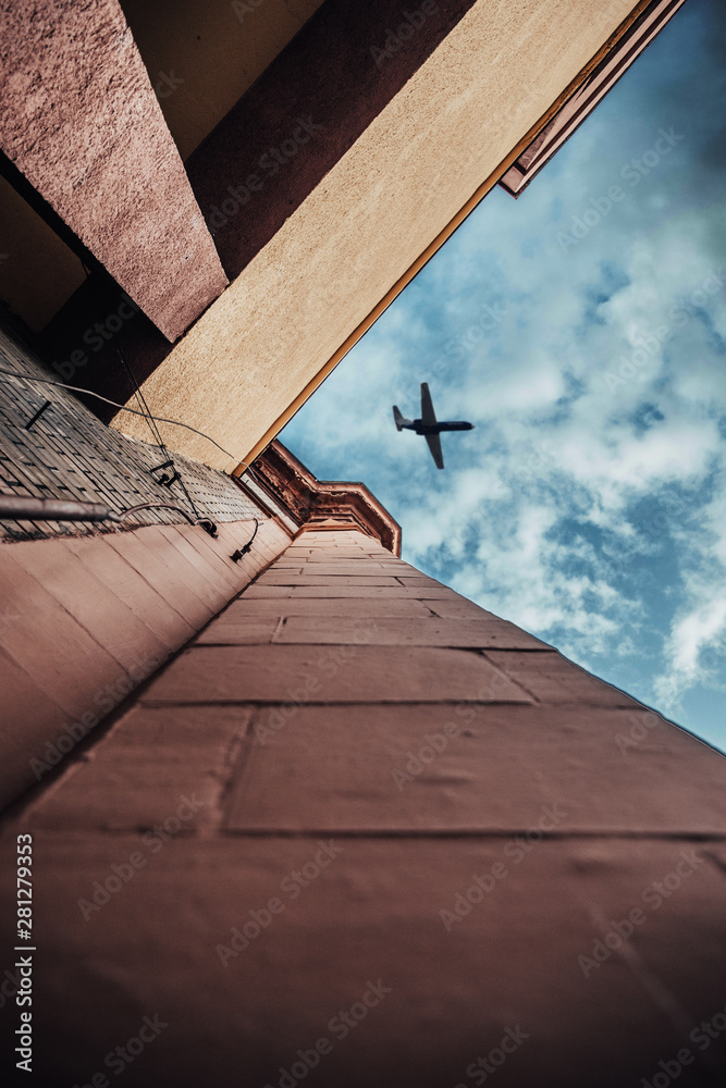 Airplane flying over the city skyscrapers. Tall city buildings and a ...