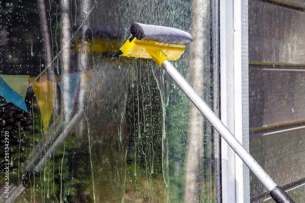 washing Windows, cleaning glasses and surfaces. yellow-white telescopic ...