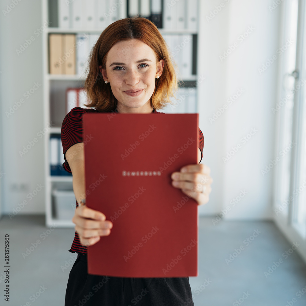 Proud young woman holding out her CV portfolio Stock Photo | Adobe Stock