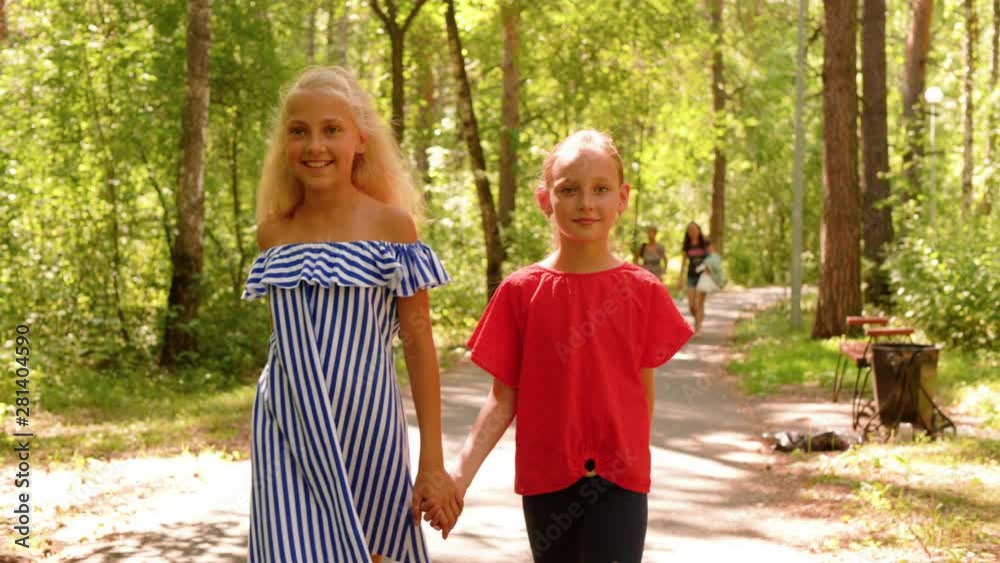 Childre friendship and happy childhood. Two teen girls friends walk in ...