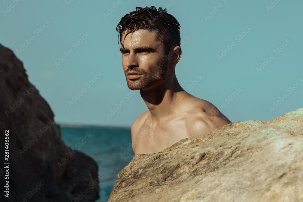 Strong face male model on the nature background with rocks and water on ...