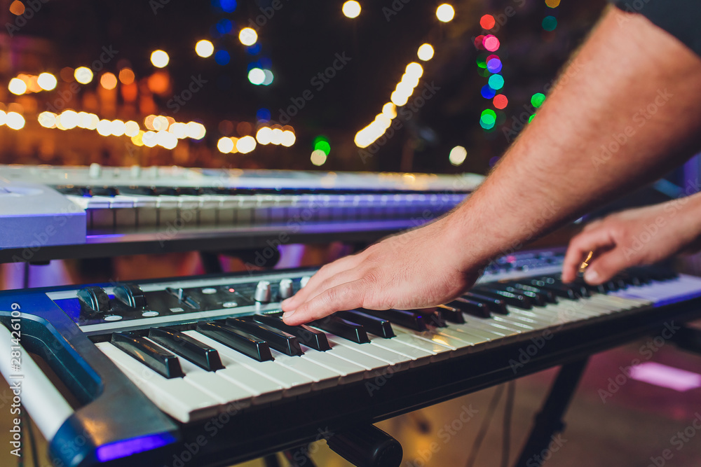 Man playing electronic musical keyboard synthesizer by hands on white ...