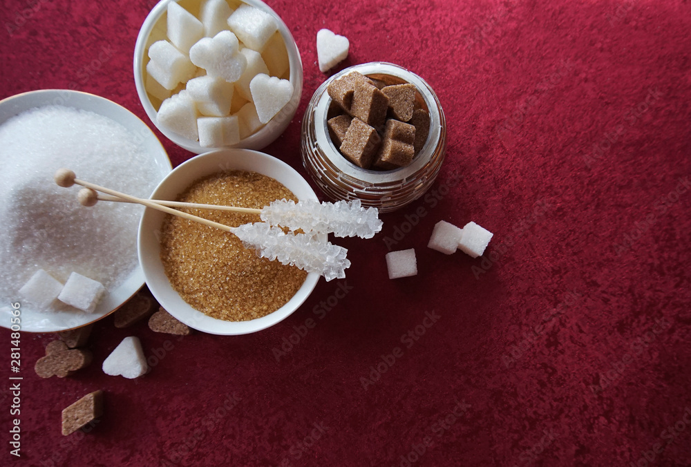 Various types and shapes of sugar on red background with empty space ...