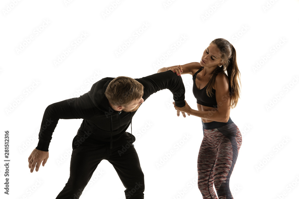 Man in black outfit and athletic caucasian woman fighting on white ...