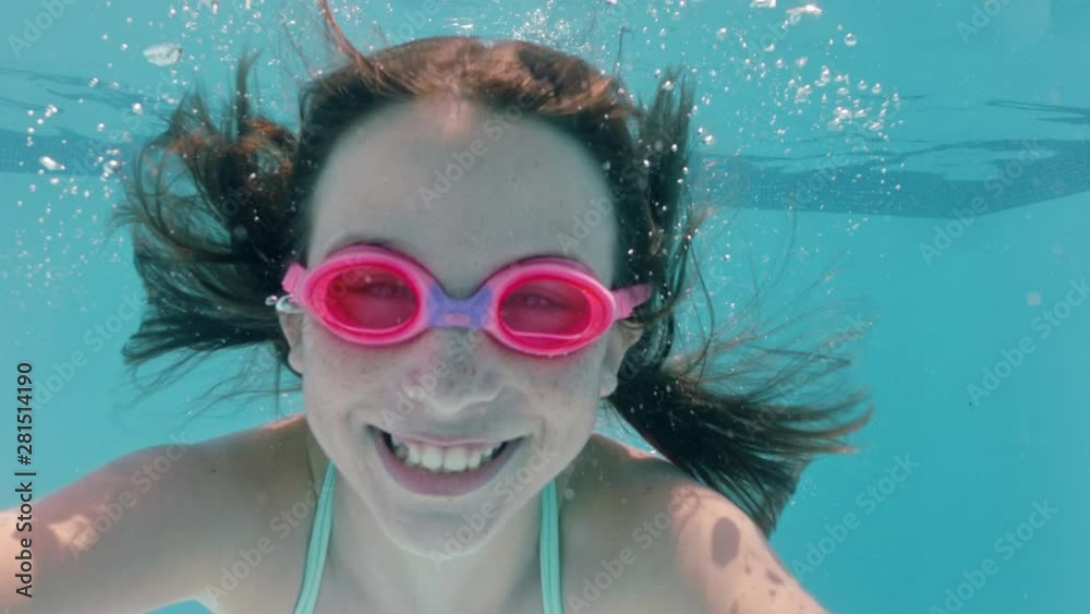 happy girl swimming underwater in pool smiling waving hand enjoying ...