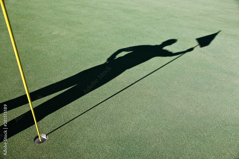 Shadow of golfer and golf flag on golf course Stock Photo | Adobe Stock