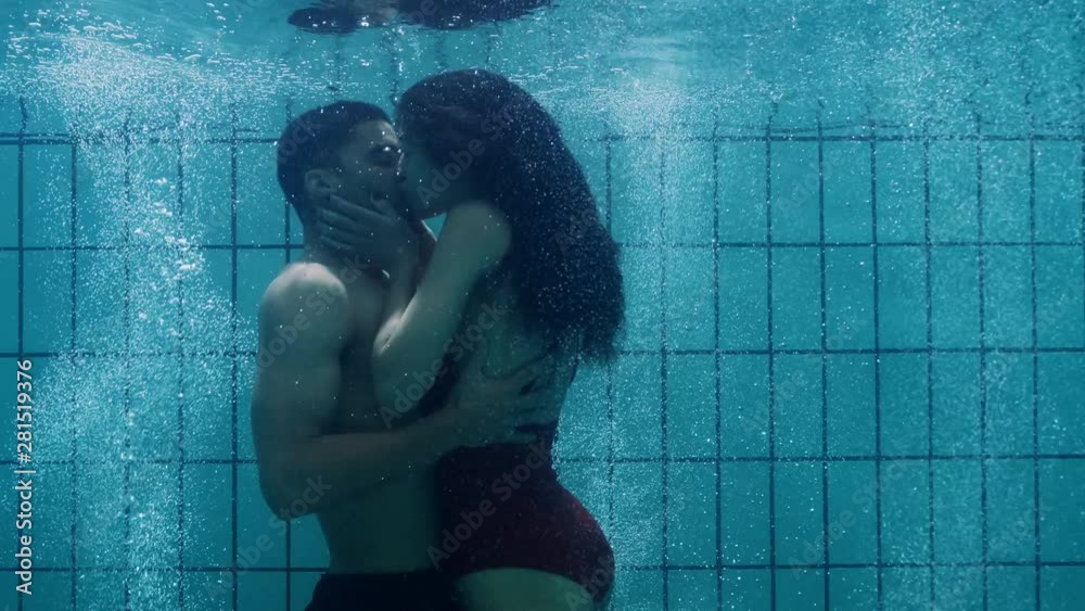romantic couple kissing underwater in swimming pool young people in ...