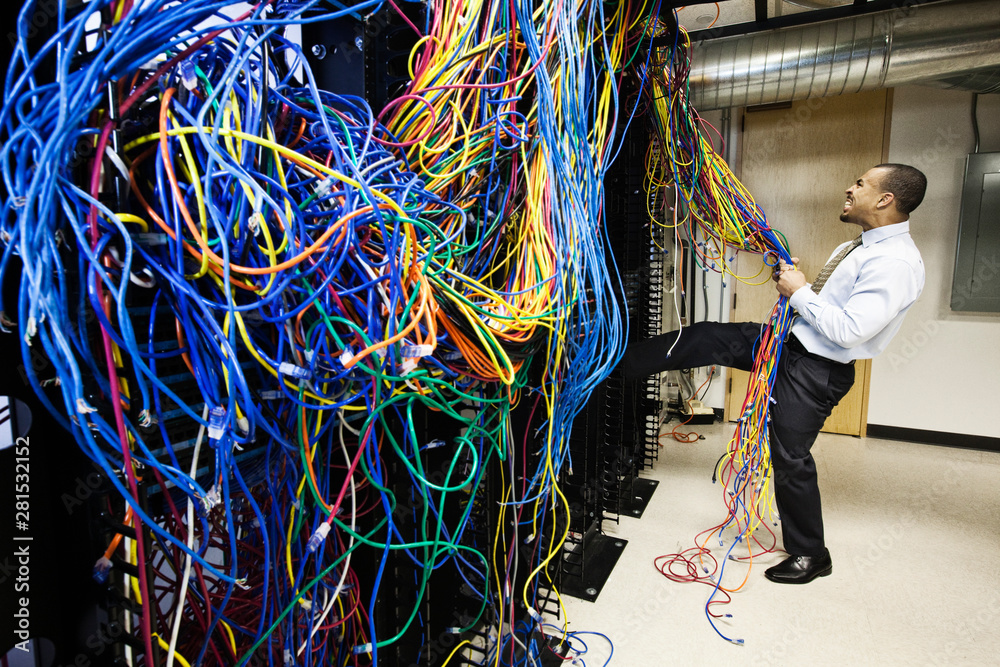 Frustrated technician pulling cat 5 cables in server room Stock 写真 ...