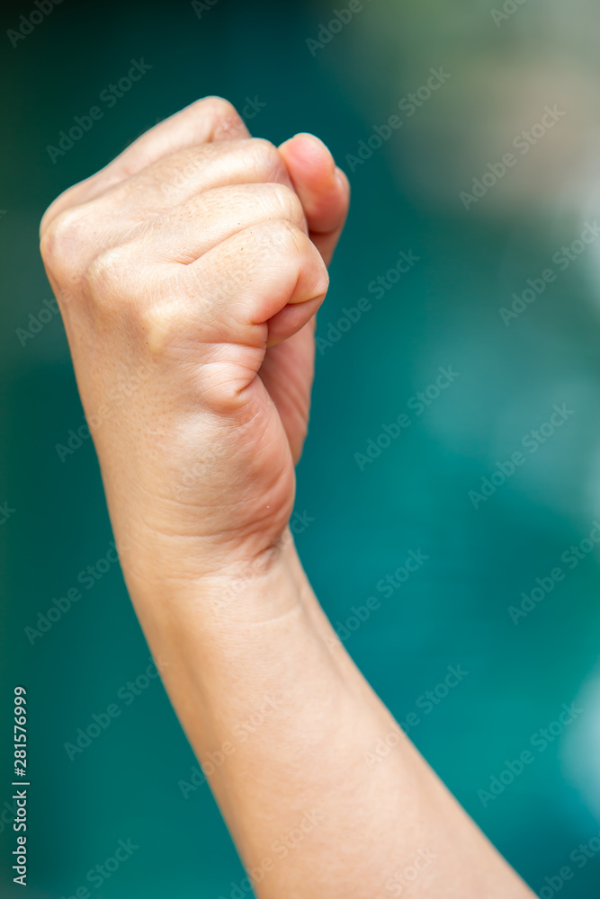 Woman's right hand in fist on bokeh blue swimming pool background ...