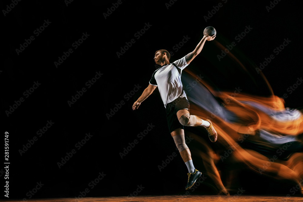 Caucasian young handball player in action and motion in mixed lights ...