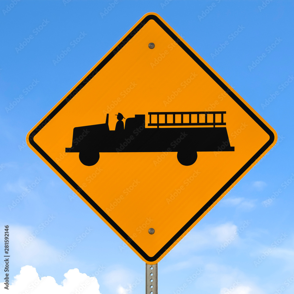 Fire Station Advance Warning sign beside a road with cloudy blue sky ...