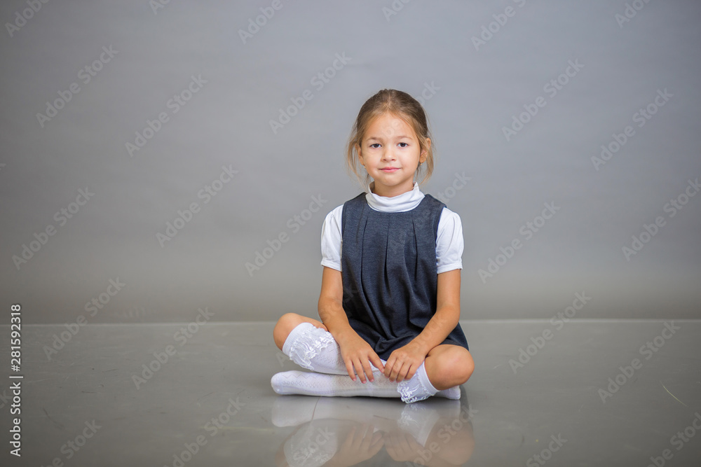 The girl the first grader in a school uniform - a gray sundress and a ...