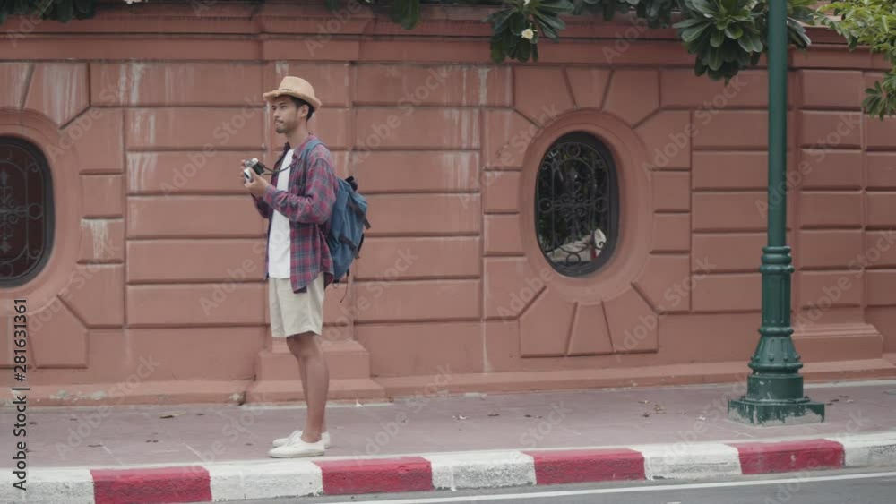Attractive handsome tourist Asian man use camera taking a photo while ...