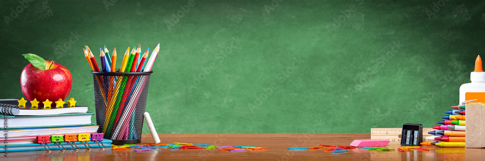 Wooden School Desk With Red Apple On Stack Of Books, Supplies And Green ...