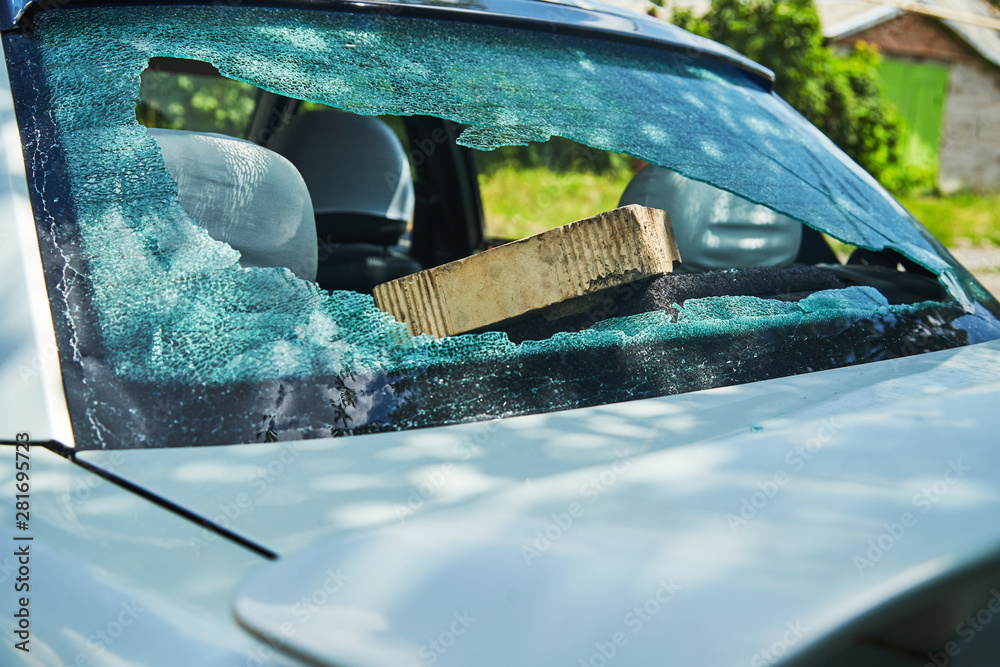 Brick in a broken rear window of a car Stock Photo | Adobe Stock