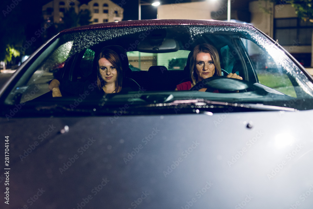 two women females in the car driving at night friends mother and ...