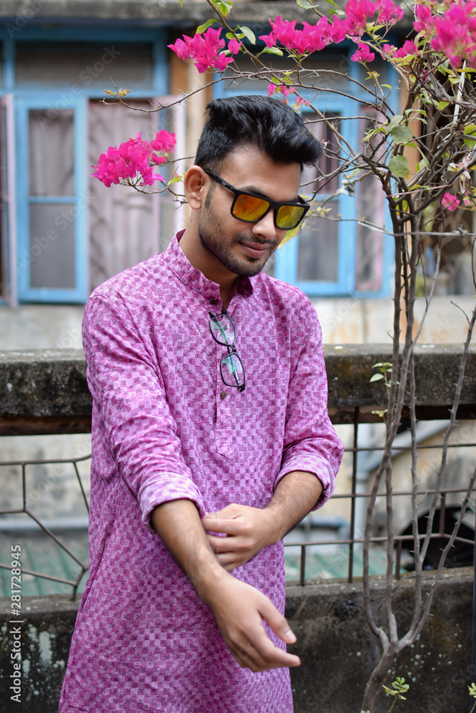Portrait of a young and handsome Indian Bengali man standing in front ...