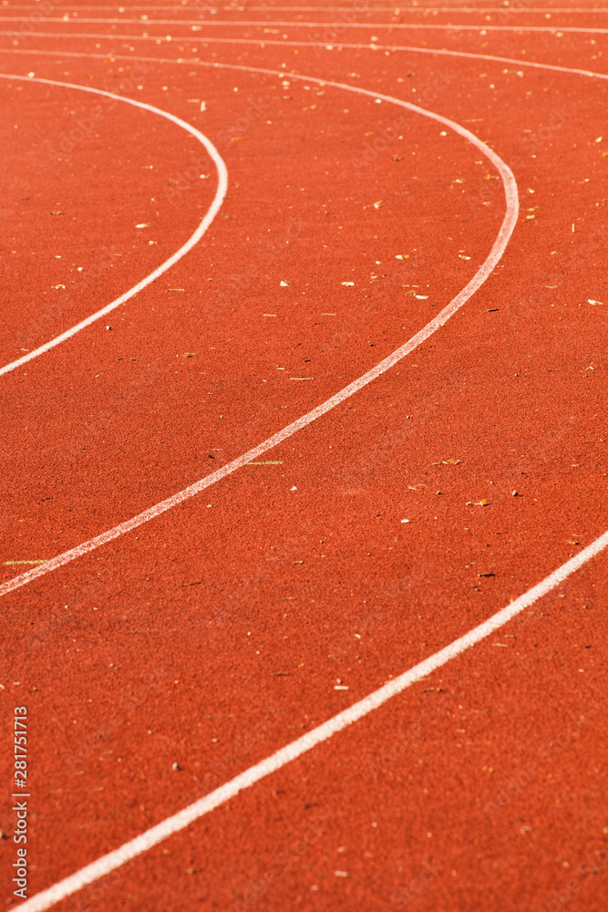 athletic red running tracks whit white lines and some leaves on it ...